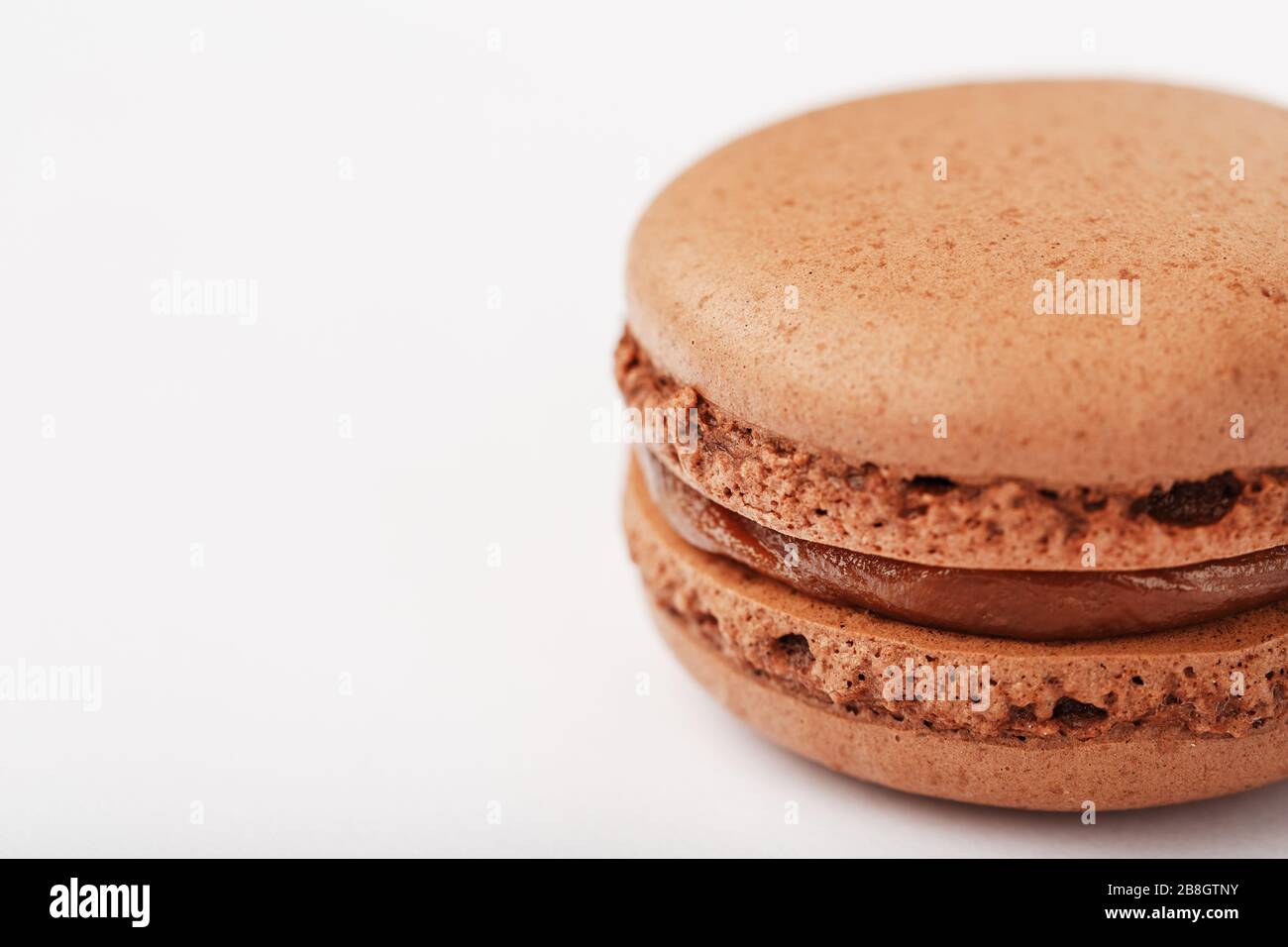 Chocolate macaroni cookies on a white background with brown filling ...
