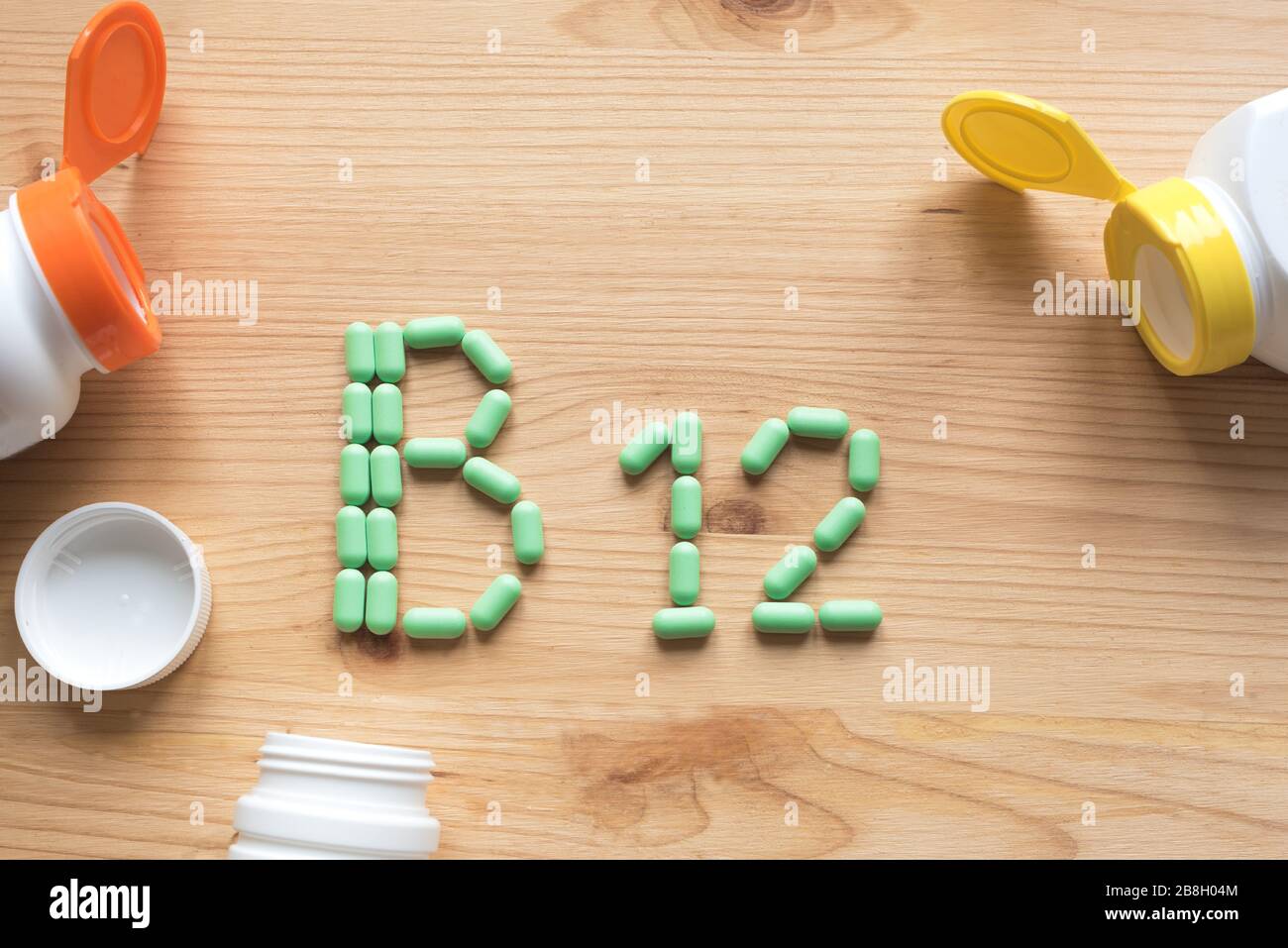 Vitamin B12. Green pills forming shape to B12 alphabet on wooden ...