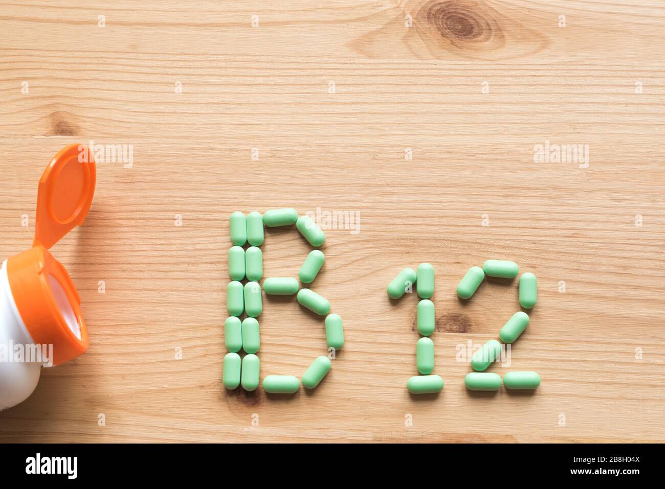 Vitamin B12. Green pills forming shape to B12 alphabet on wooden ...