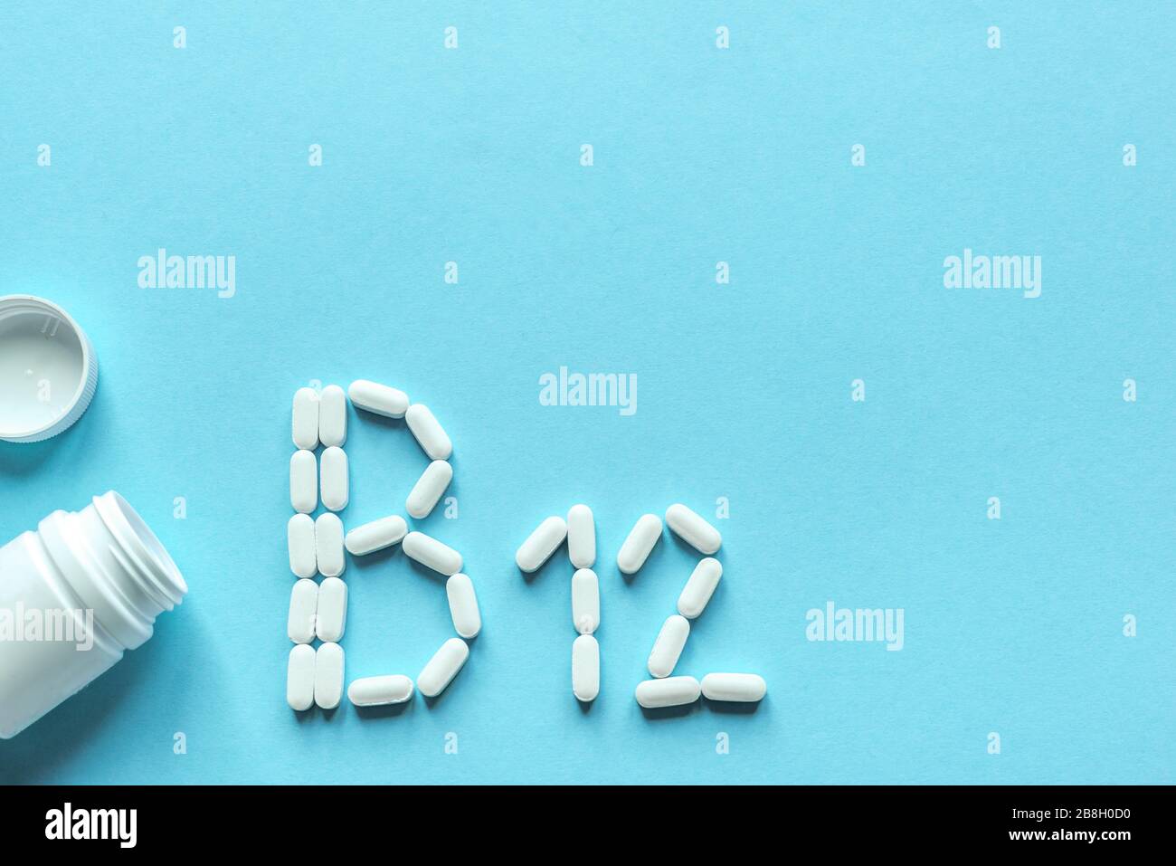 Vitamin B12. White pills forming shape to B12 alphabet on blue ...