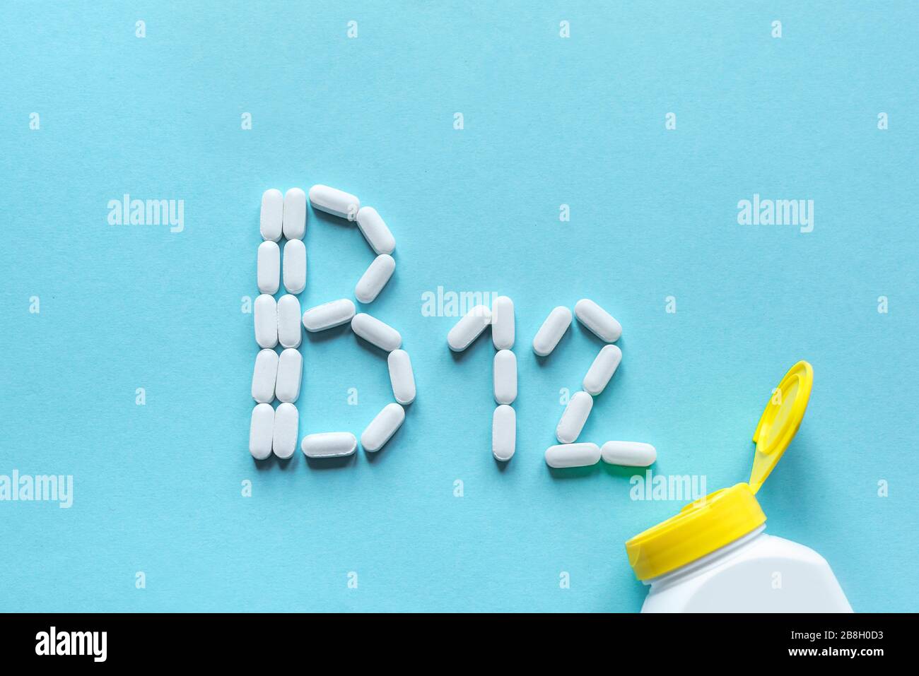Vitamin B12. White pills forming shape to B12 alphabet on blue ...