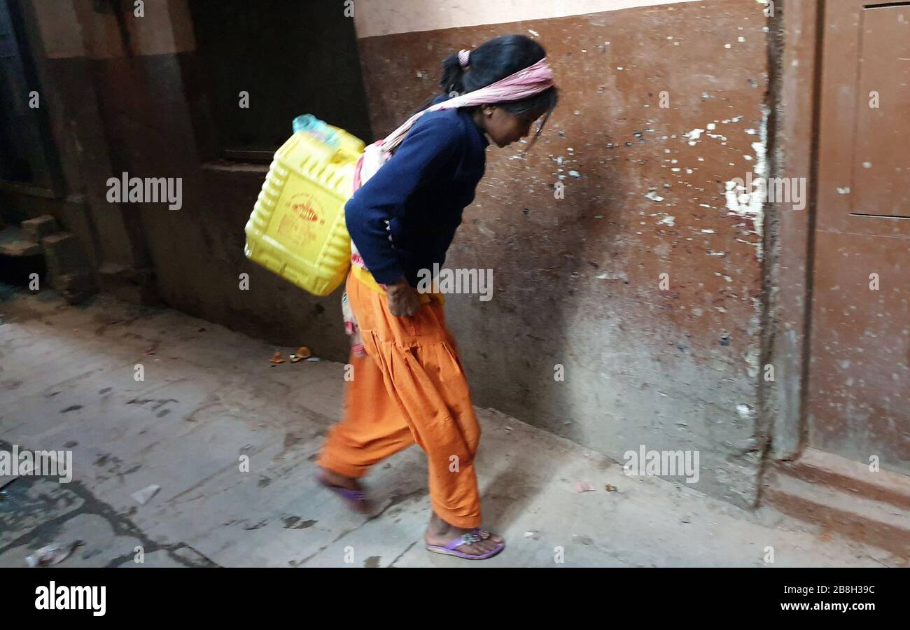Kathmandu, Nepal. 22nd Mar, 2020. A small girl carries the filled water ...
