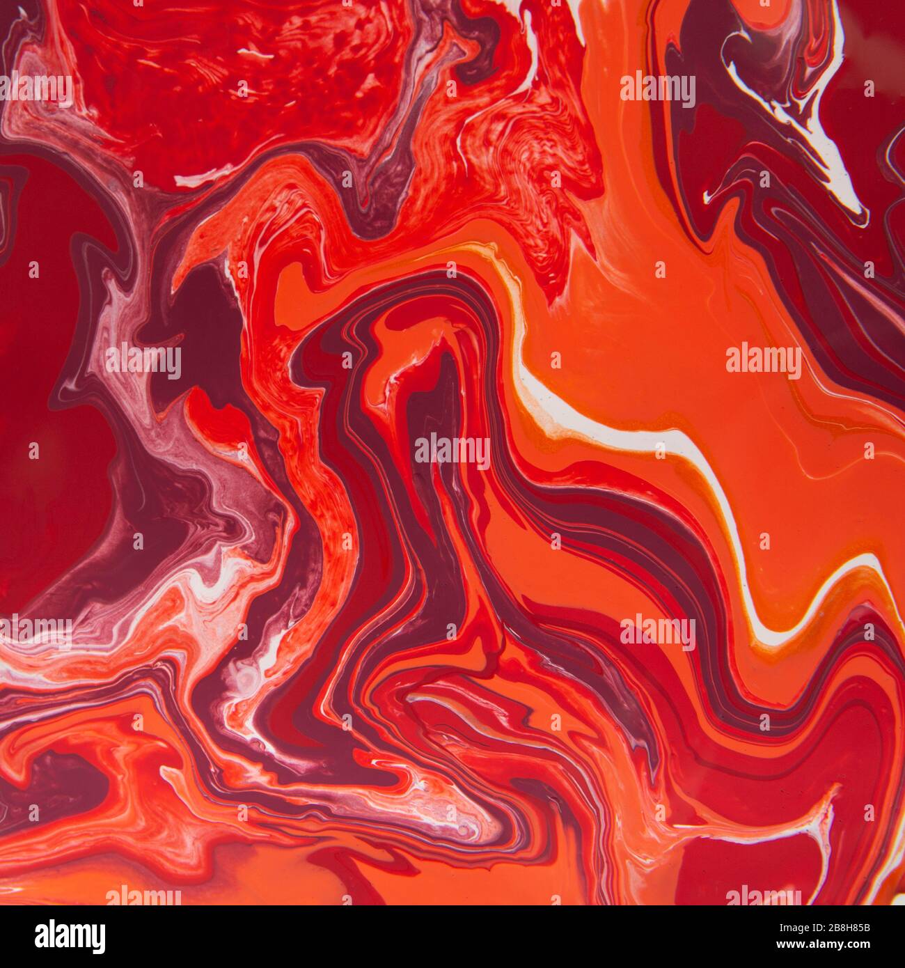Vibrant red colour stains with white spots of liquid acrylic colors ...