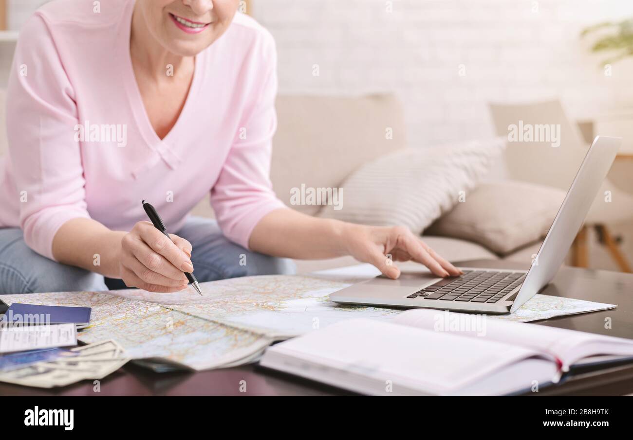 Senior woman choosing route on map at home Stock Photo - Alamy