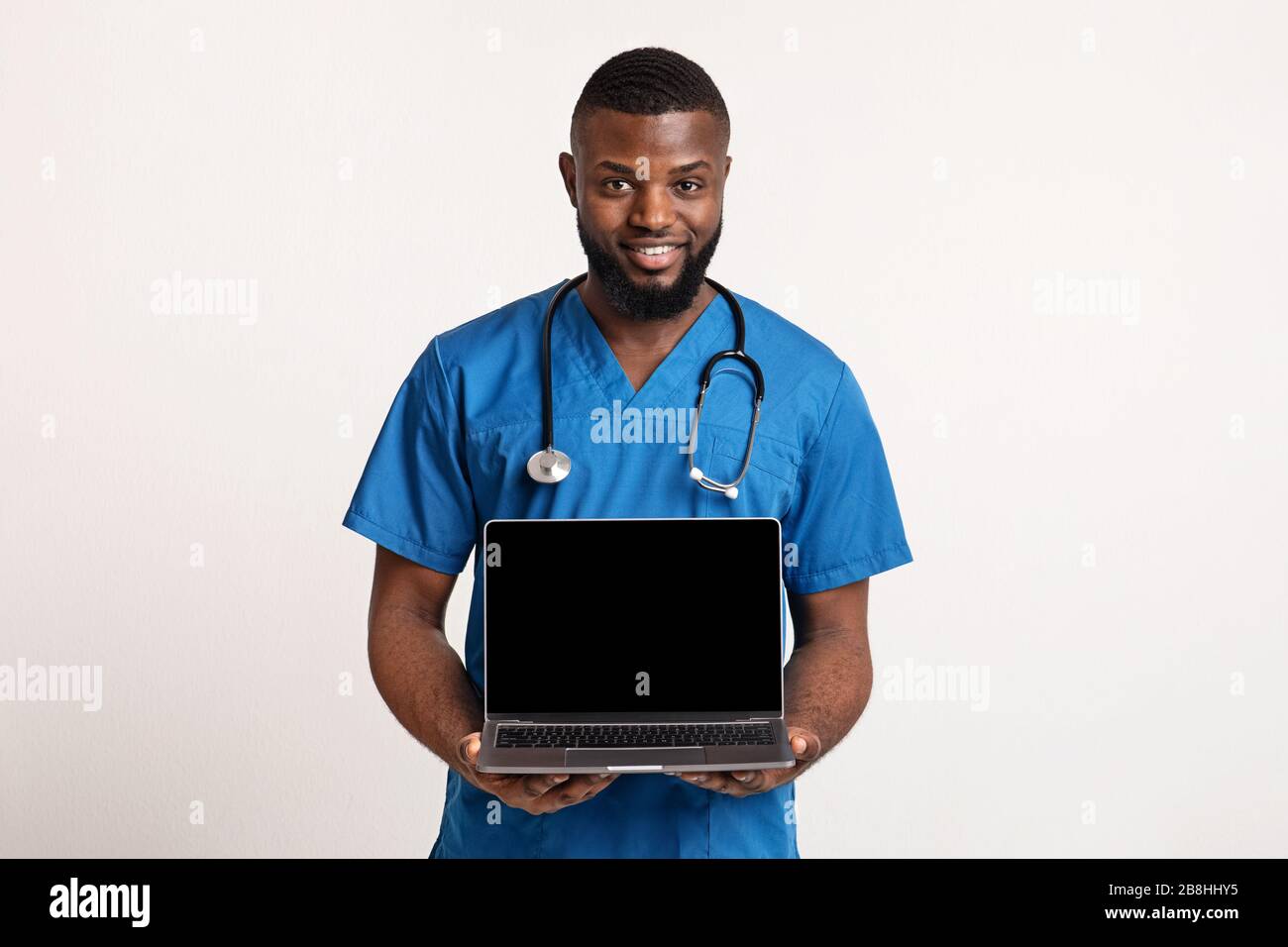 Black cheerful surgeon holding blank laptop screen Stock Photo - Alamy