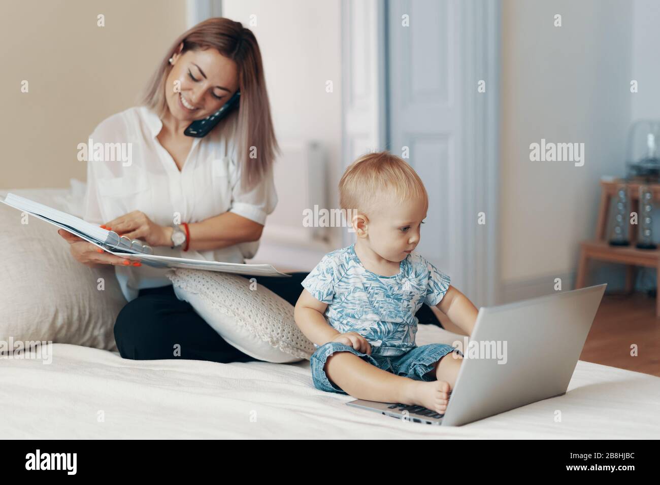 Business mom talking on a cell phone. Multi-tasking, freelance and ...