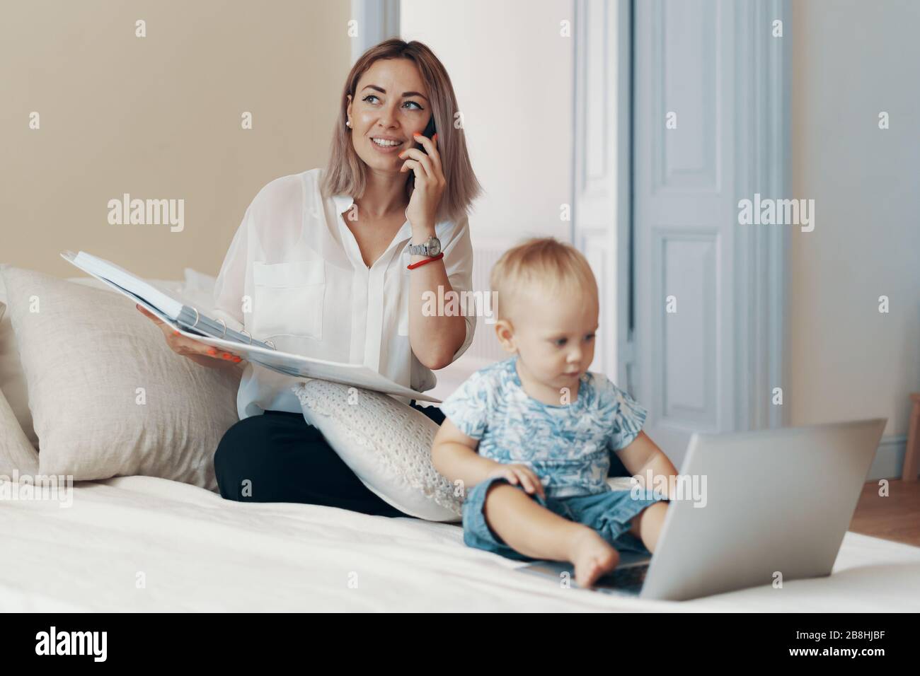 Business mom talking on a cell phone. Multi-tasking, freelance and ...