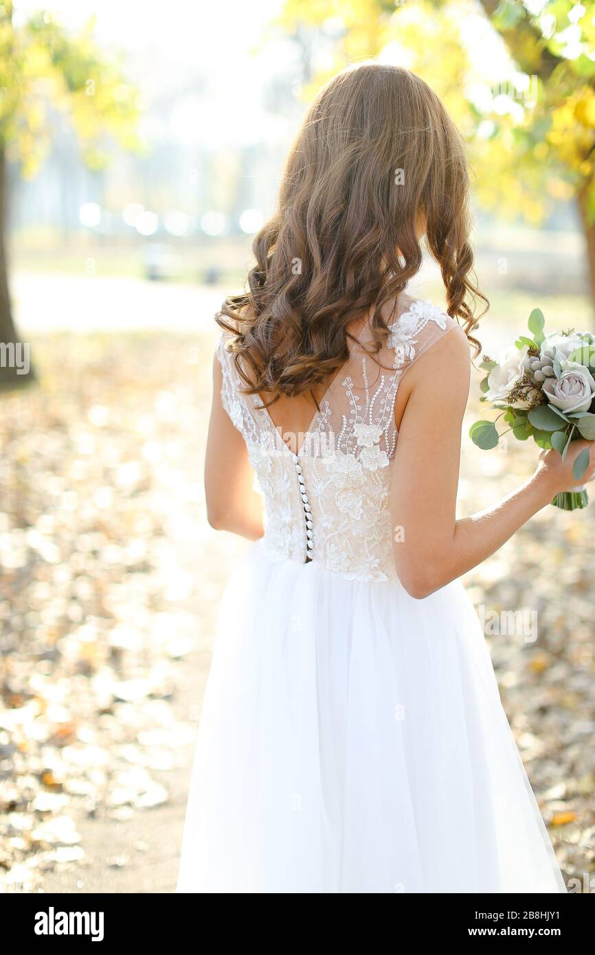 Back view bride walking and keeping bouquet of roses Stock Photo - Alamy