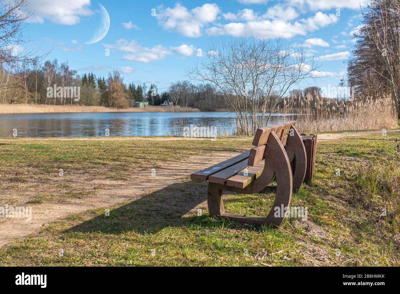 above a small lake the big bright quarter moon can be seen during the ...