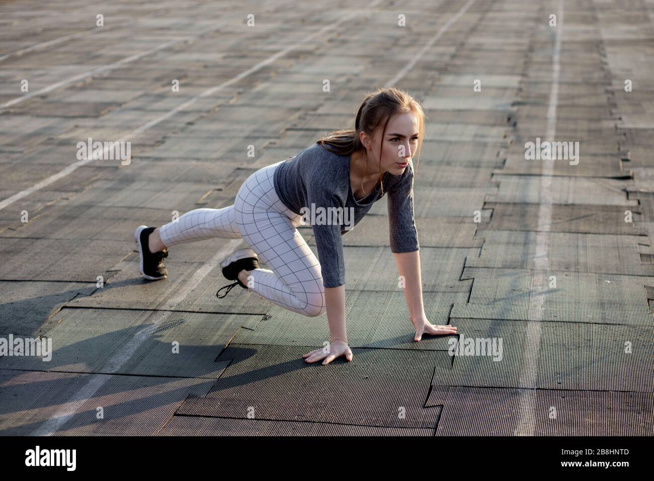 Female runner stretching legs on running track Stock Photo - Alamy
