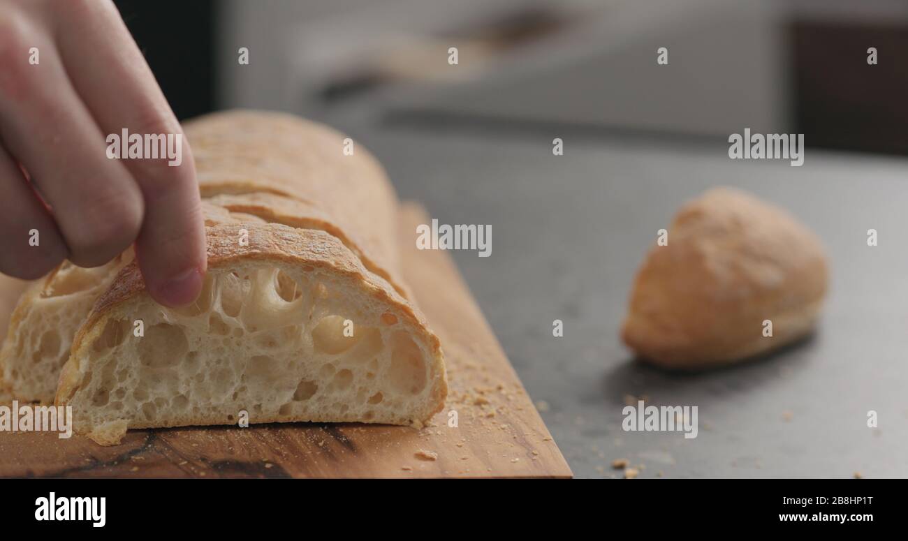man hand touching ciabatta slices on olive board, wide photo Stock ...