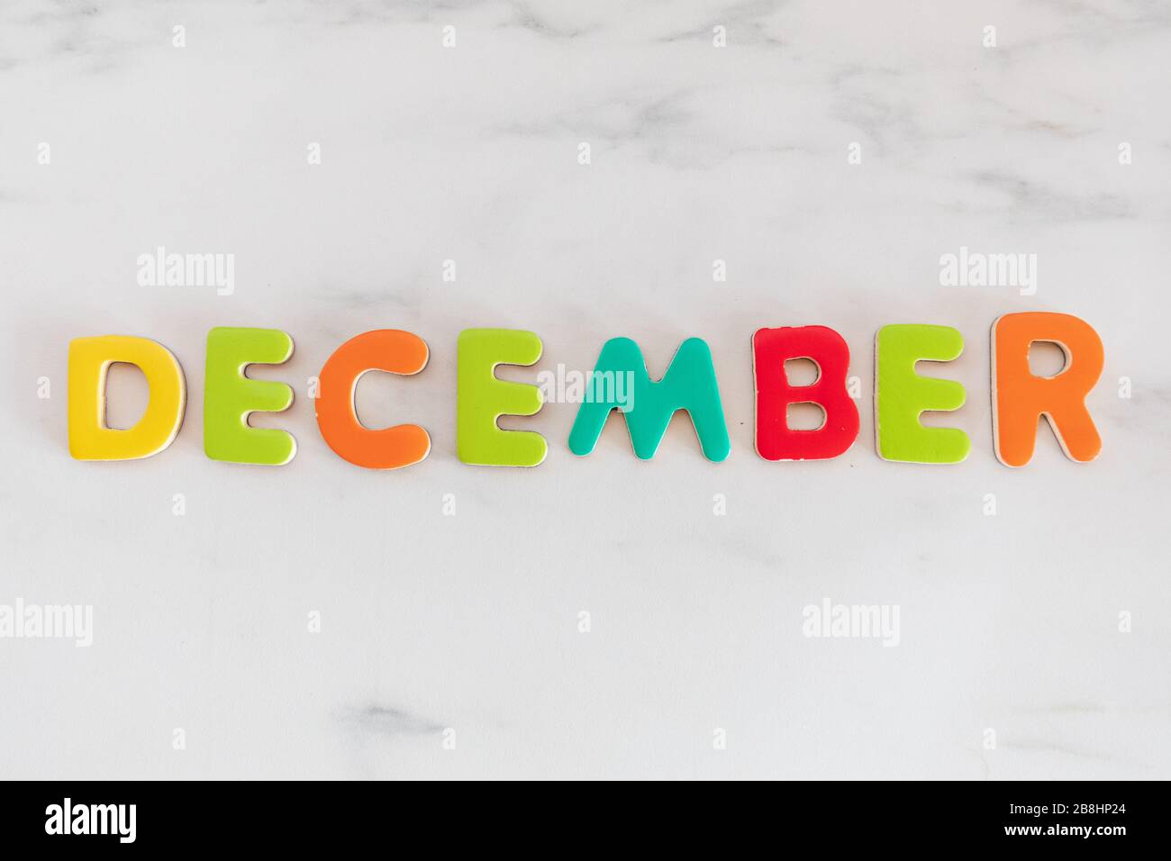 December word written with colorful letters on white marble stone ...