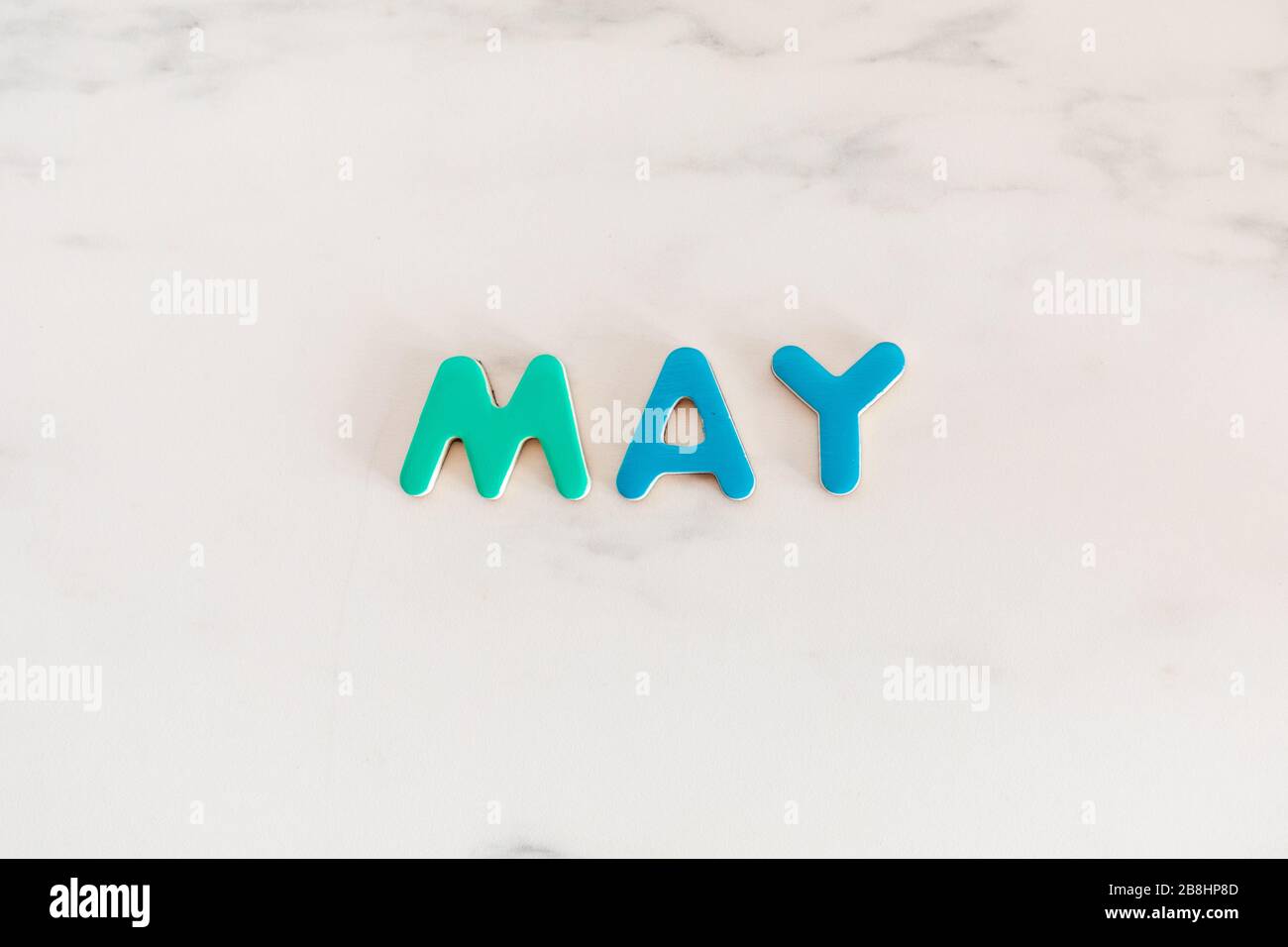 May word written with colorful letters on white marble stone background ...