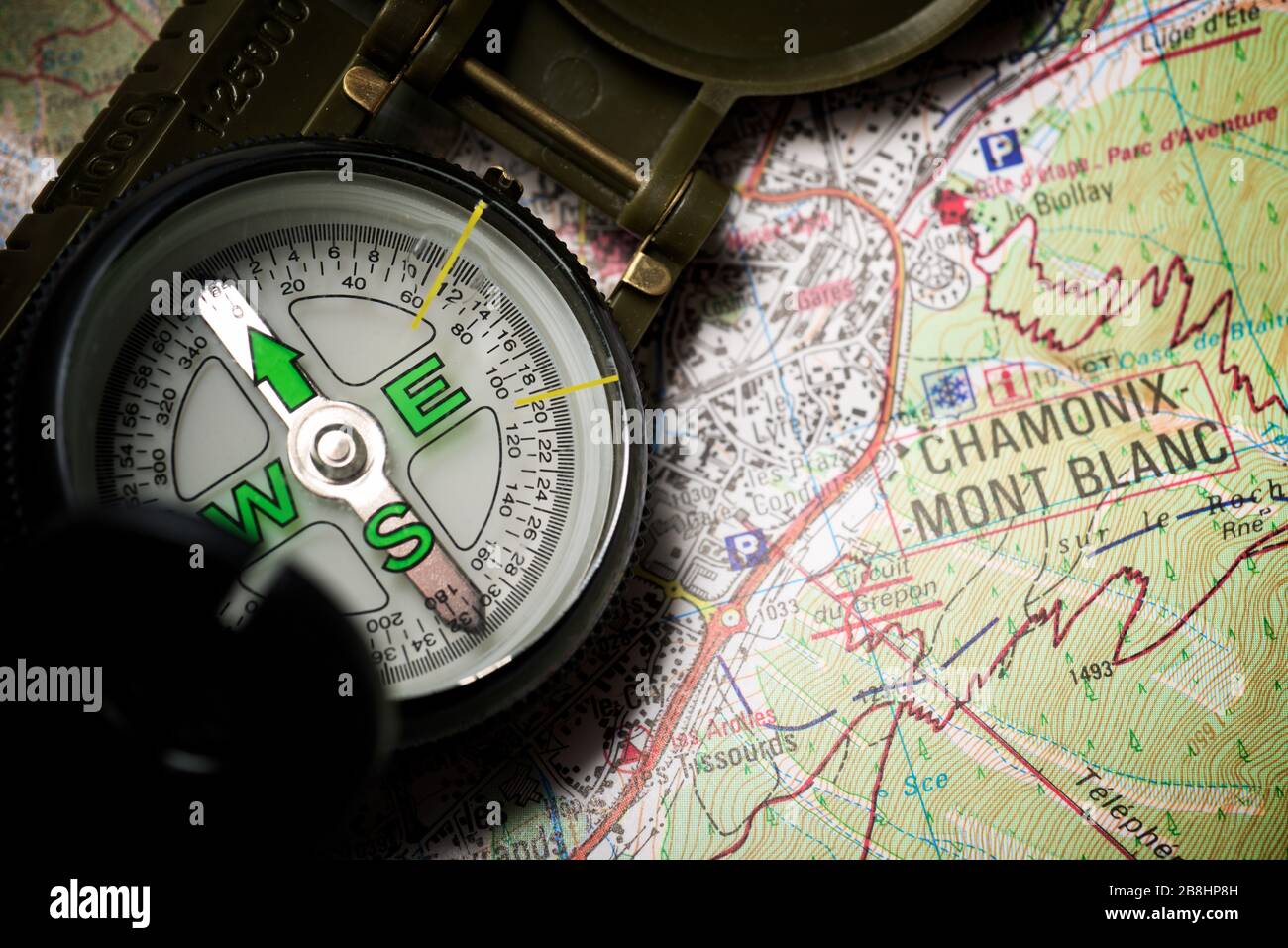 Compass on a cartographic map of the Alps Stock Photo - Alamy