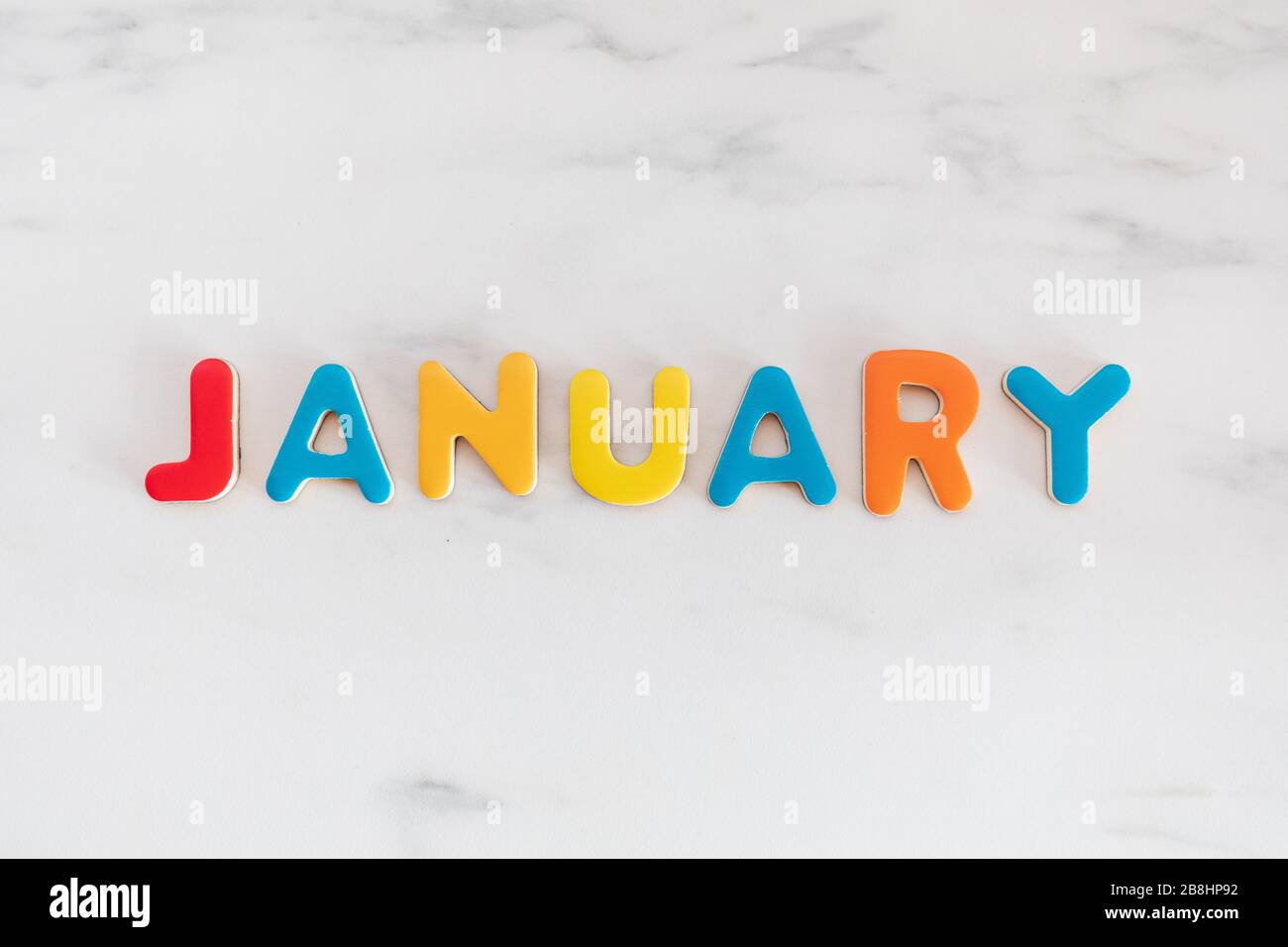 January word written with colorful letters on white marble stone ...