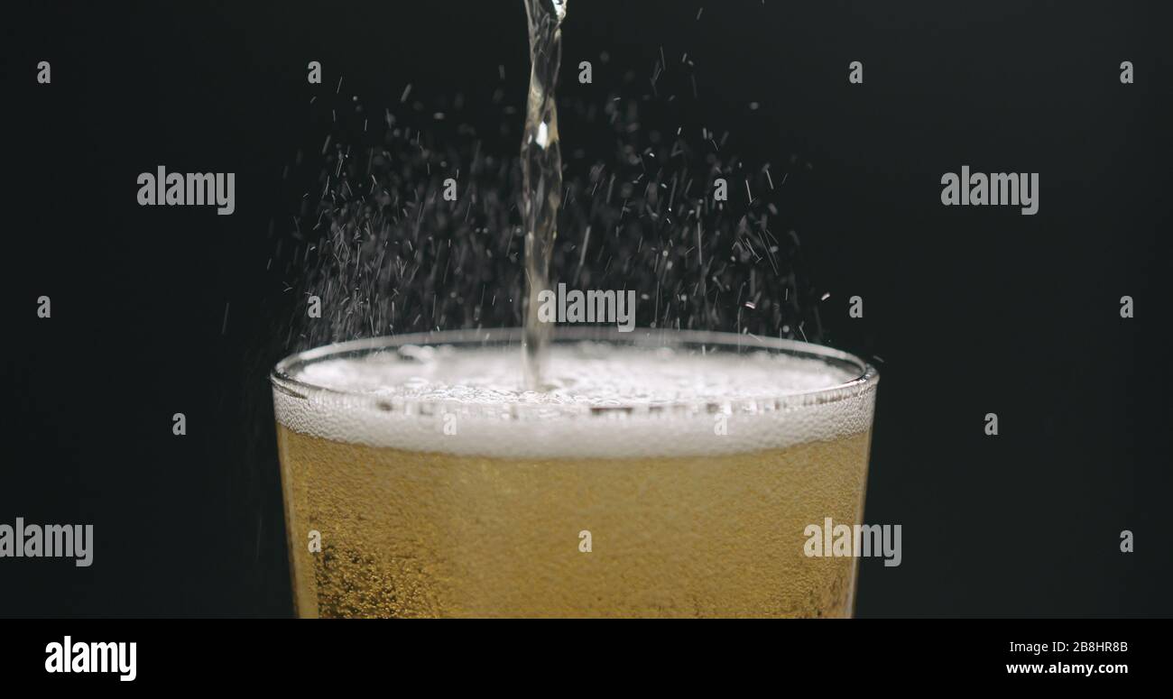 pour cider into glass with zoom out on black background, wide photo ...