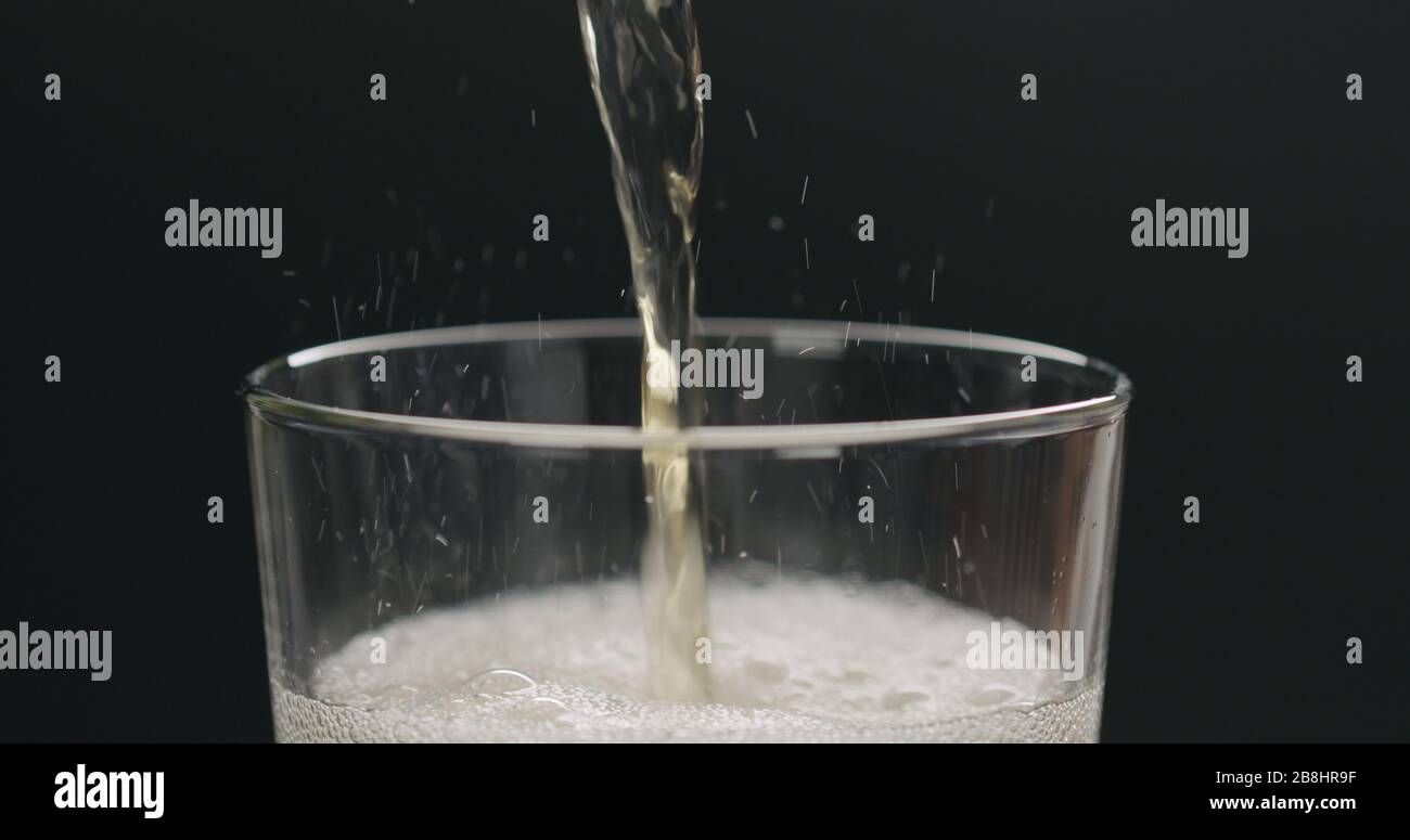 pour cider into glass with zoom out on black background, wide photo ...