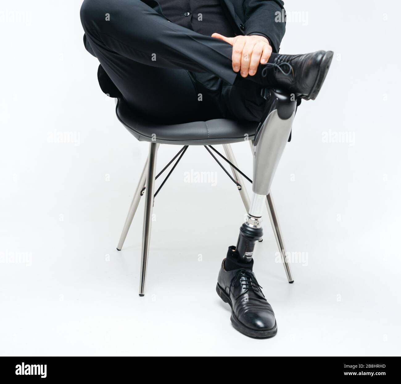 Cropped view of disabled young man with prosthetic leg sitting on a ...