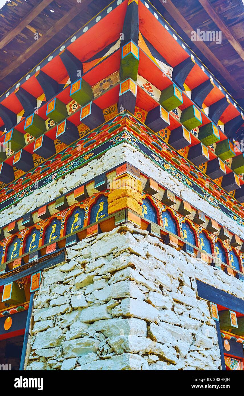 The colorful elements of carved timber roof of Bhutanese shrine with ...