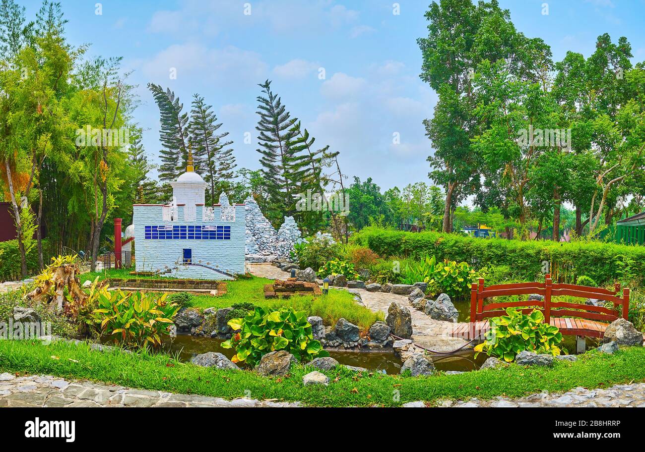 The beautiful Nepal garden with pond, small wooden bridge, Buddhist ...