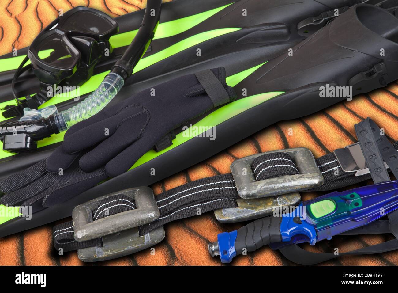 Flippers, mask, snorkel, diving knife and belt on the sea sand ...