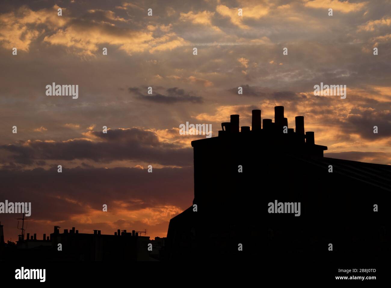 Paris roofline at dusk with chimney pots in silhouette , drifting ...