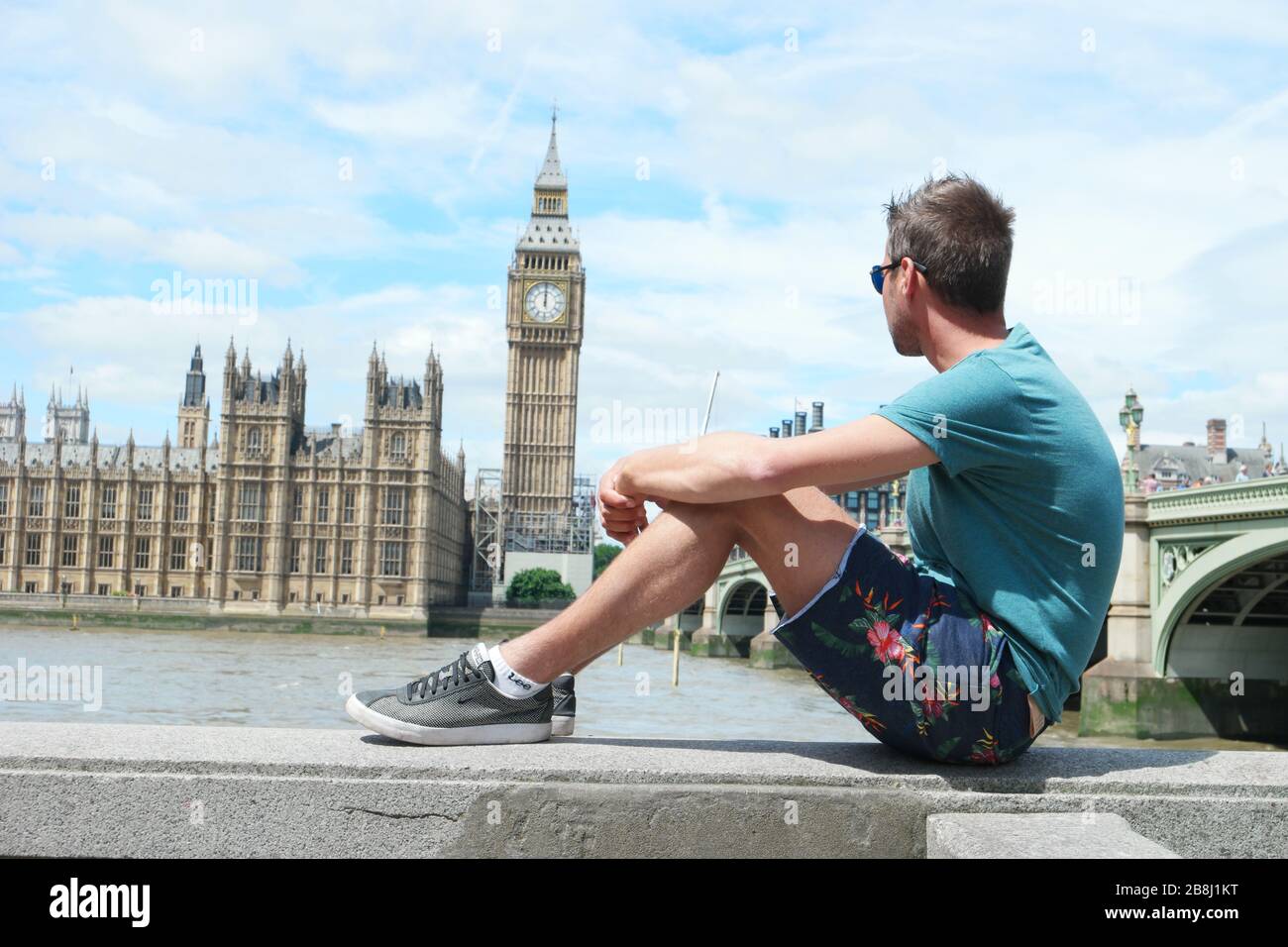 guy on city trip in London, youn men at waterfront by the river Thames ...