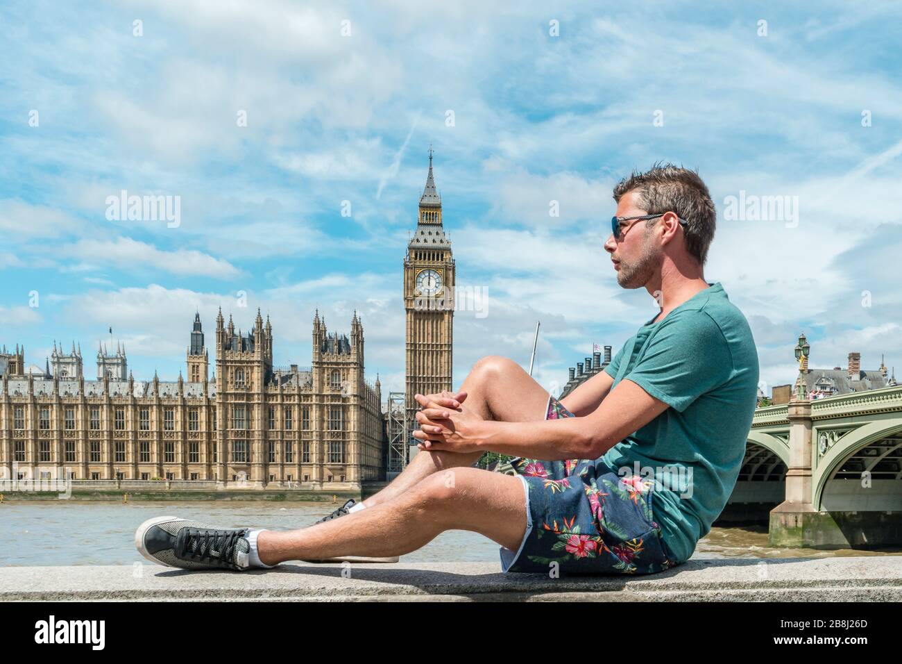 guy on city trip in London, youn men at waterfront by the river Thames ...