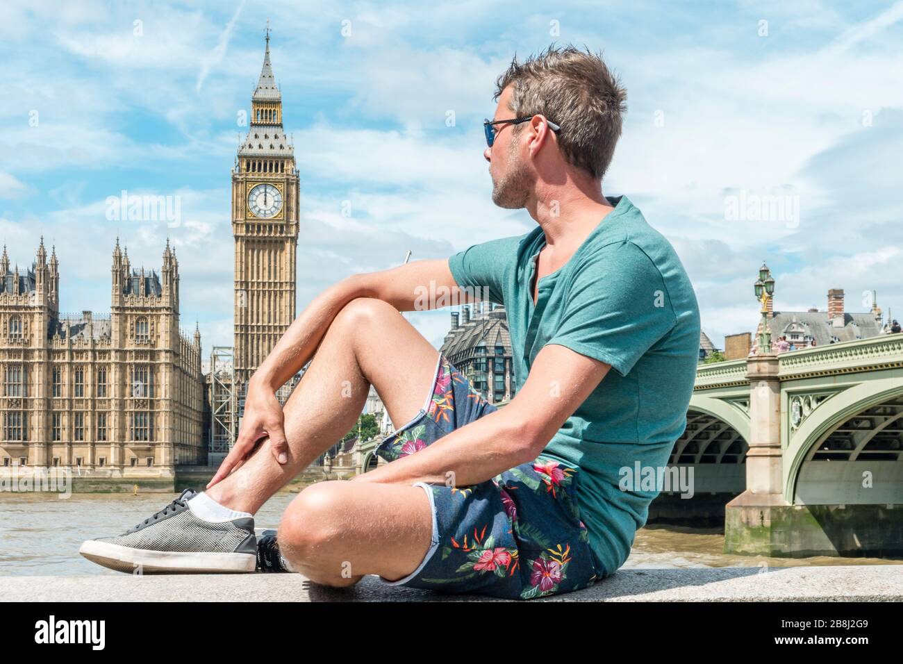 guy on city trip in London, youn men at waterfront by the river Thames ...