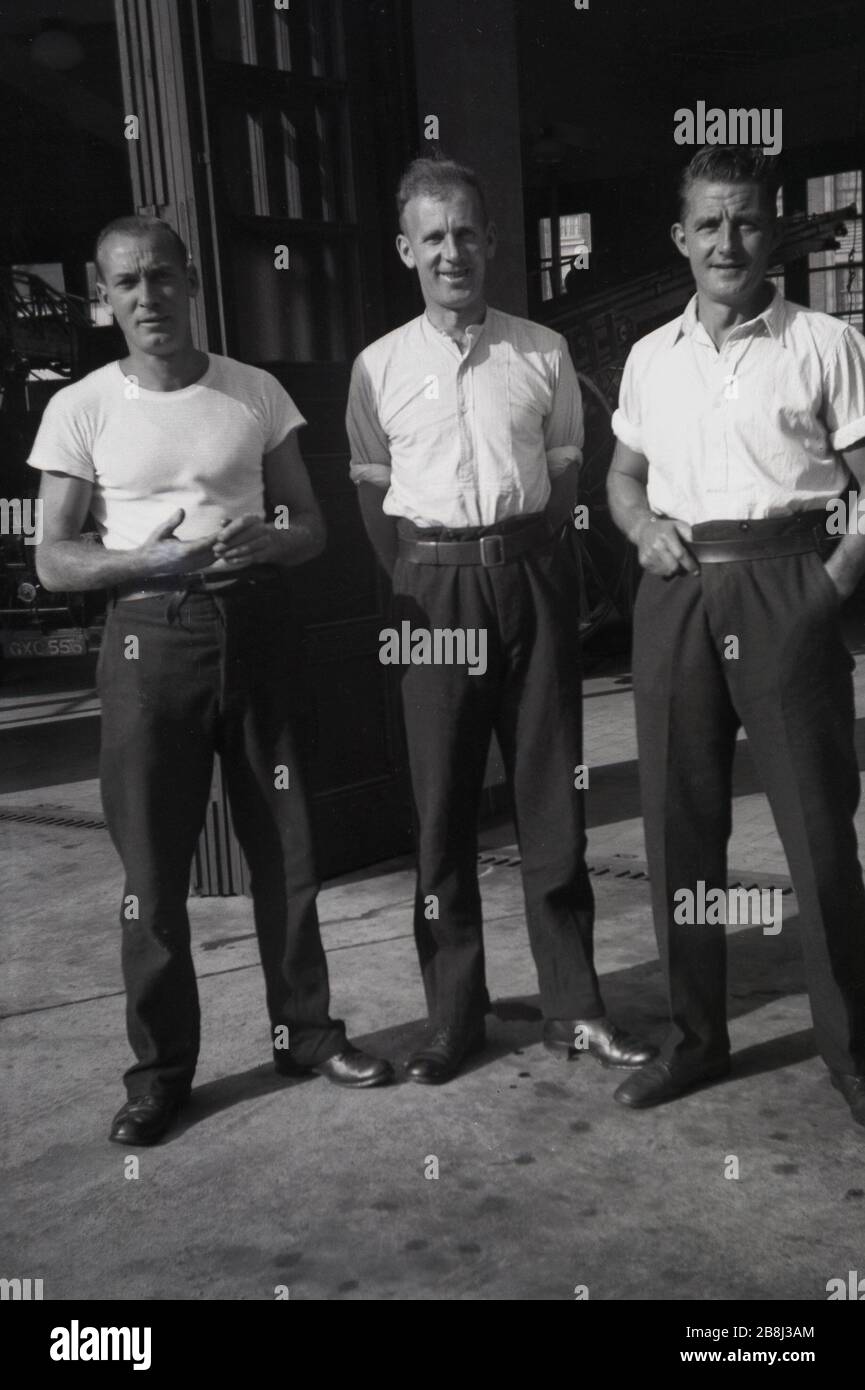 1950, historical three fireman, not in full uniform, standing outside ...
