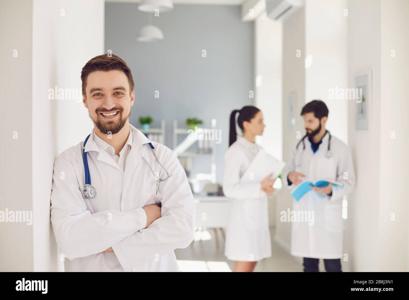 A practicing doctor with a stethoscope smiles against the background of ...