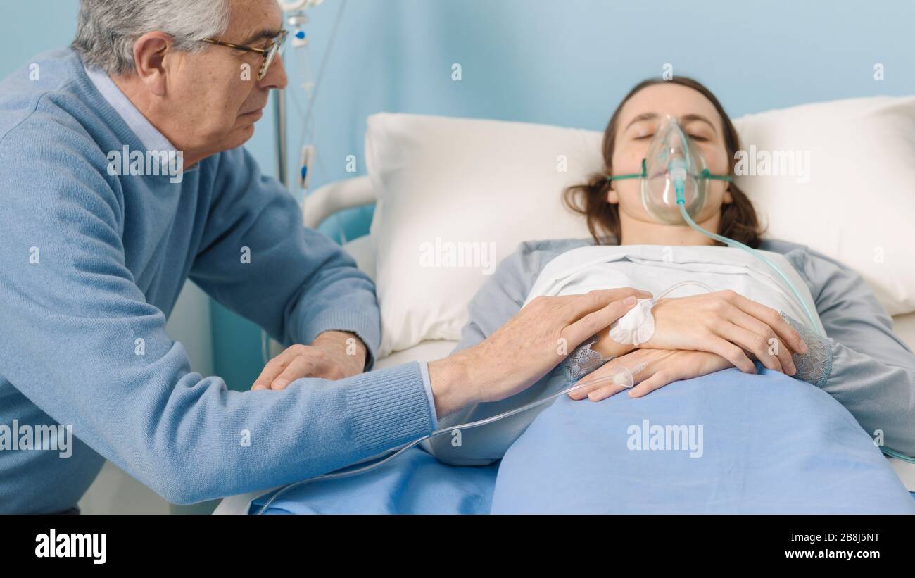 Caring concerned father assisting her sick daughter at the hospital and ...