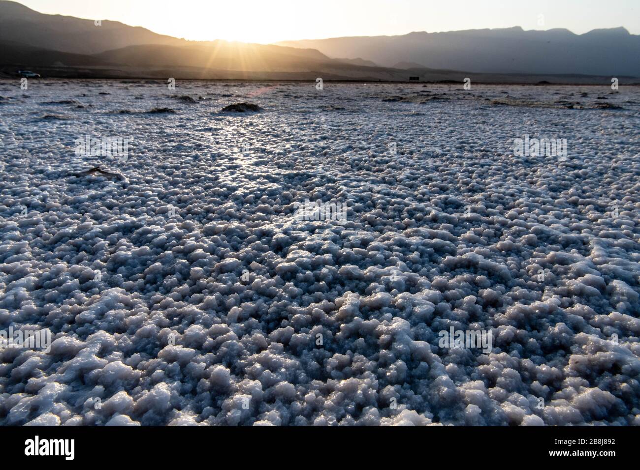 Africa, Djibouti, Lake Assal. Salt texture on the ground with mountains ...