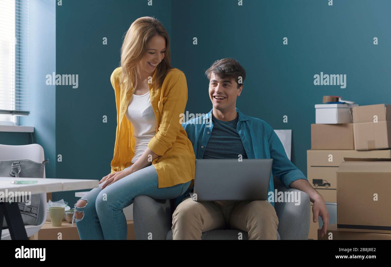 Happy young couple moving in their new home, they are sitting on the ...