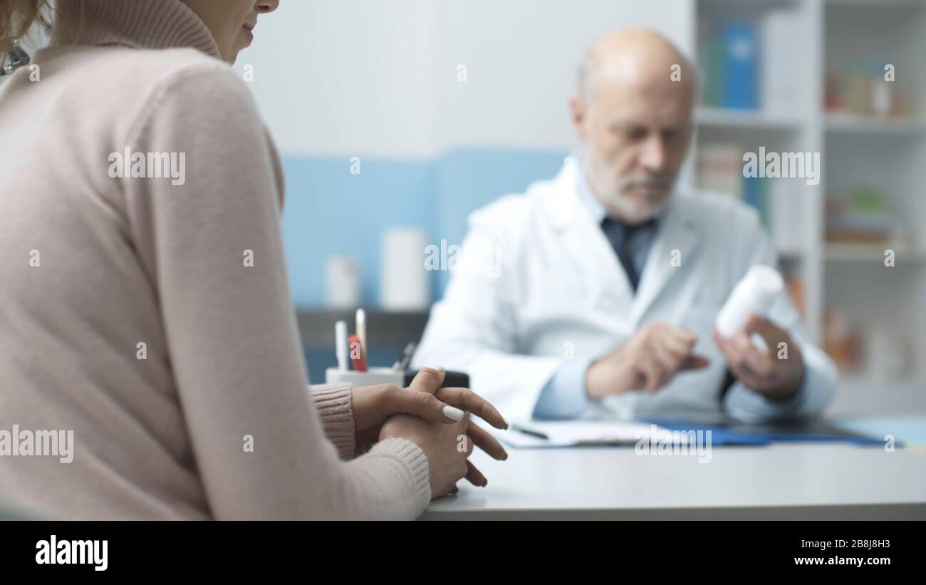 Professional senior doctor meeting a patient in the office and giving a ...