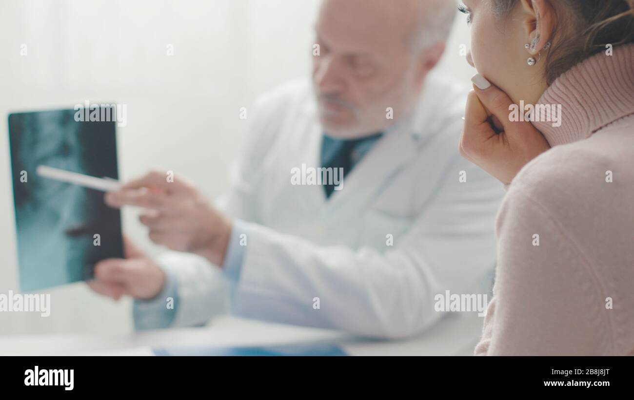 Professional radiologist sitting at desk and checking a patient's x-ray ...