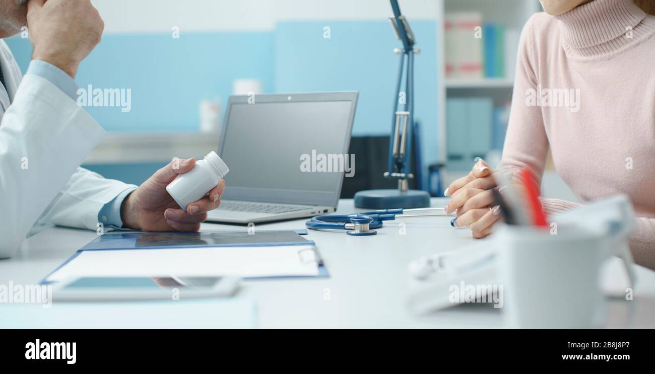 Professional senior doctor meeting a patient in the office and giving a ...