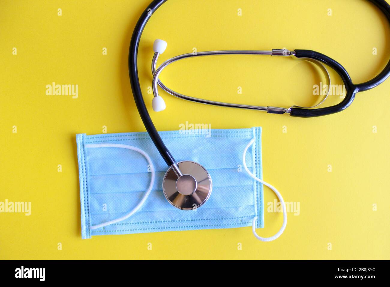Top view black stethoscope on yellow background. For check heart or ...