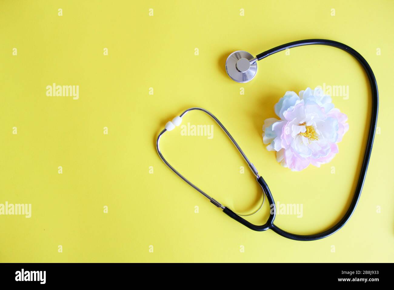 Top view black stethoscope on yellow background. For check heart or ...