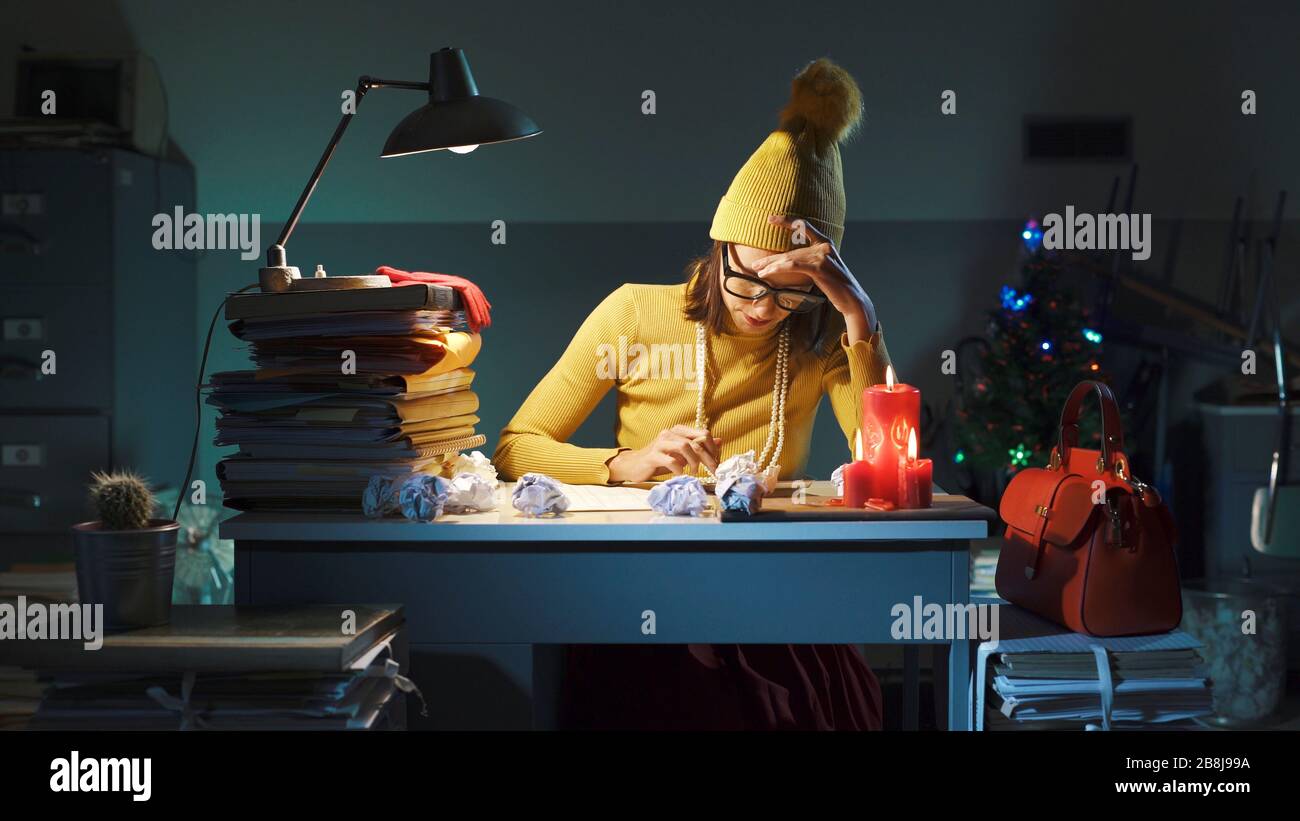 Efficient secretary working late at night in the office on Christmas ...
