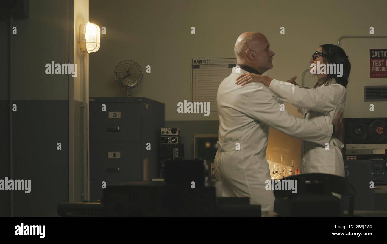 Couple of scientists dancing together in a vintage style lab and ...