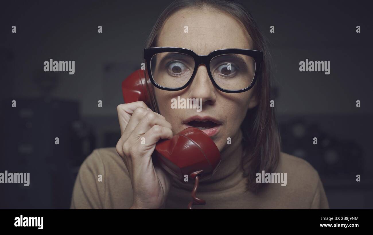 Shocked gasping woman talking on the phone, she is receiving bad news ...