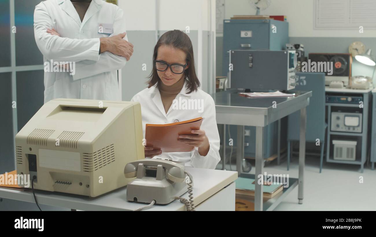Scientific team working in the laboratory using vintage machinery and ...