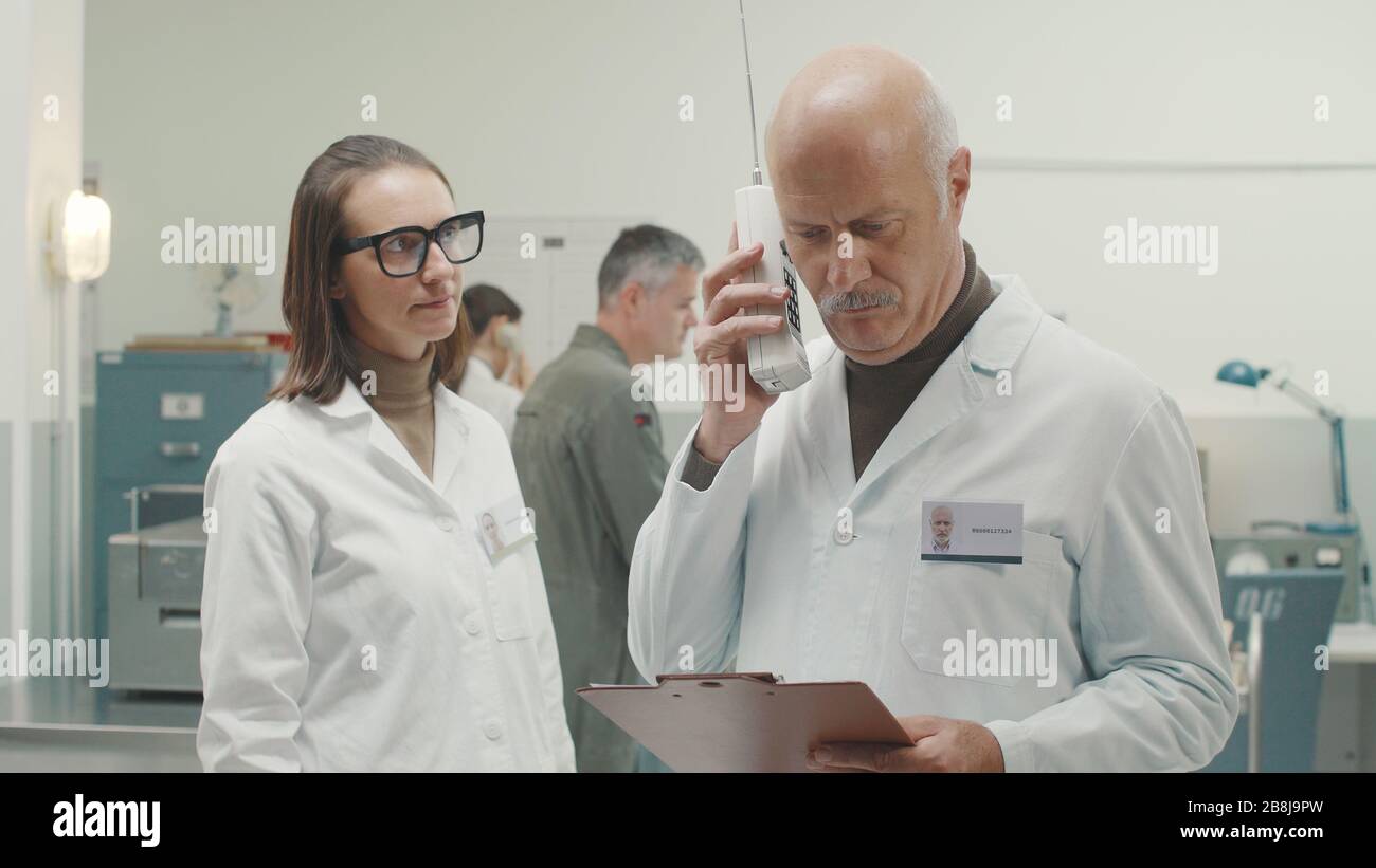 Professional chief scientist receiving an important phone call, retro ...