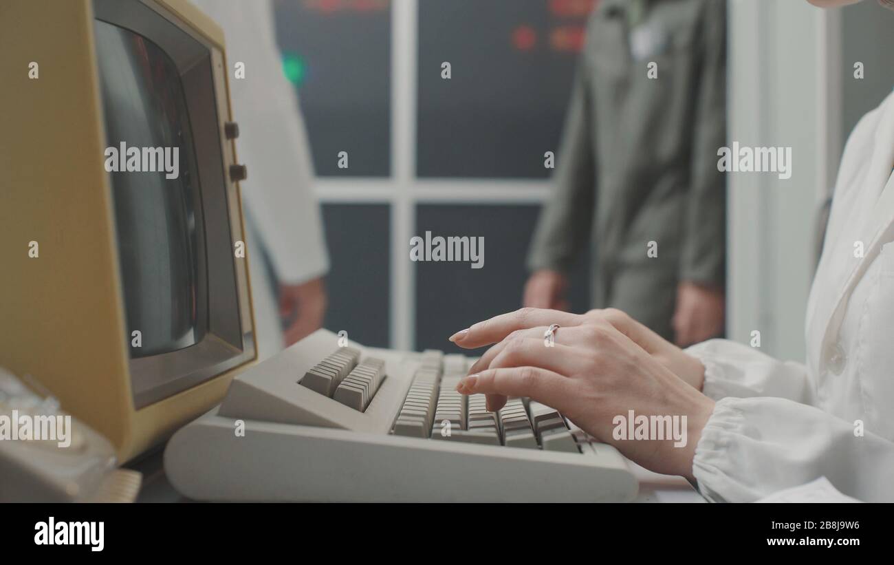 Woman working with an old vintage computer in a laboratory, data ...
