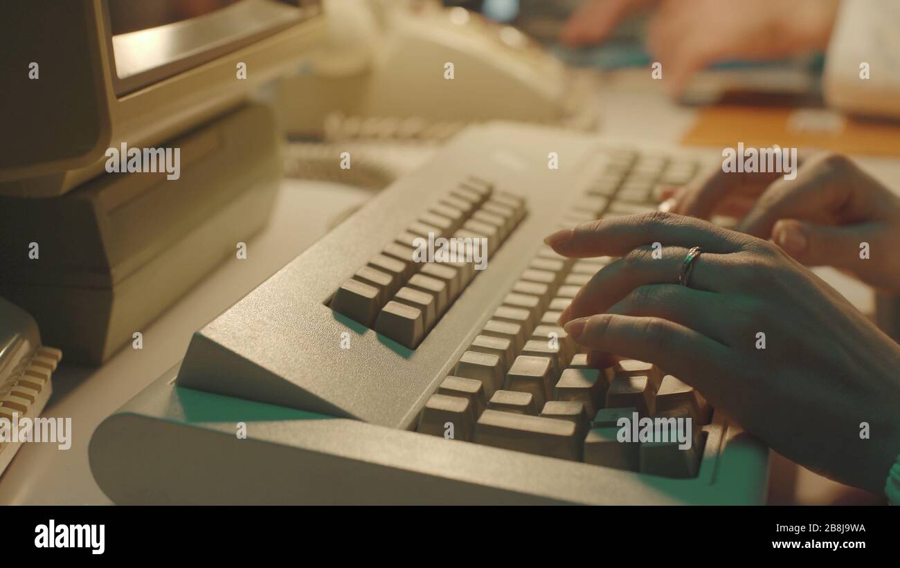 Scientist typing on a keyboard and using computer in a vintage lab ...