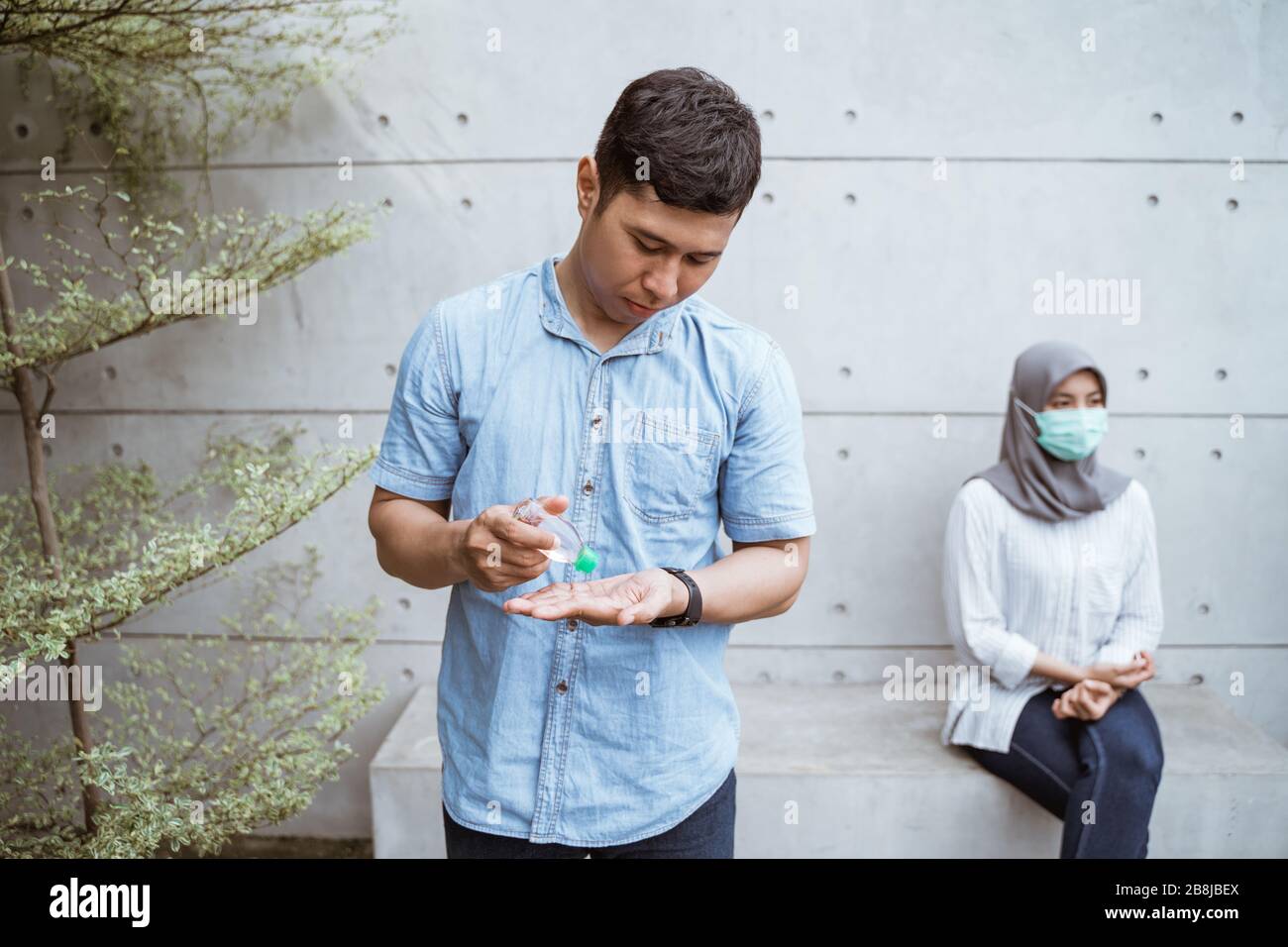 social distancing. man appying hand sanitizer while meeting with friend ...