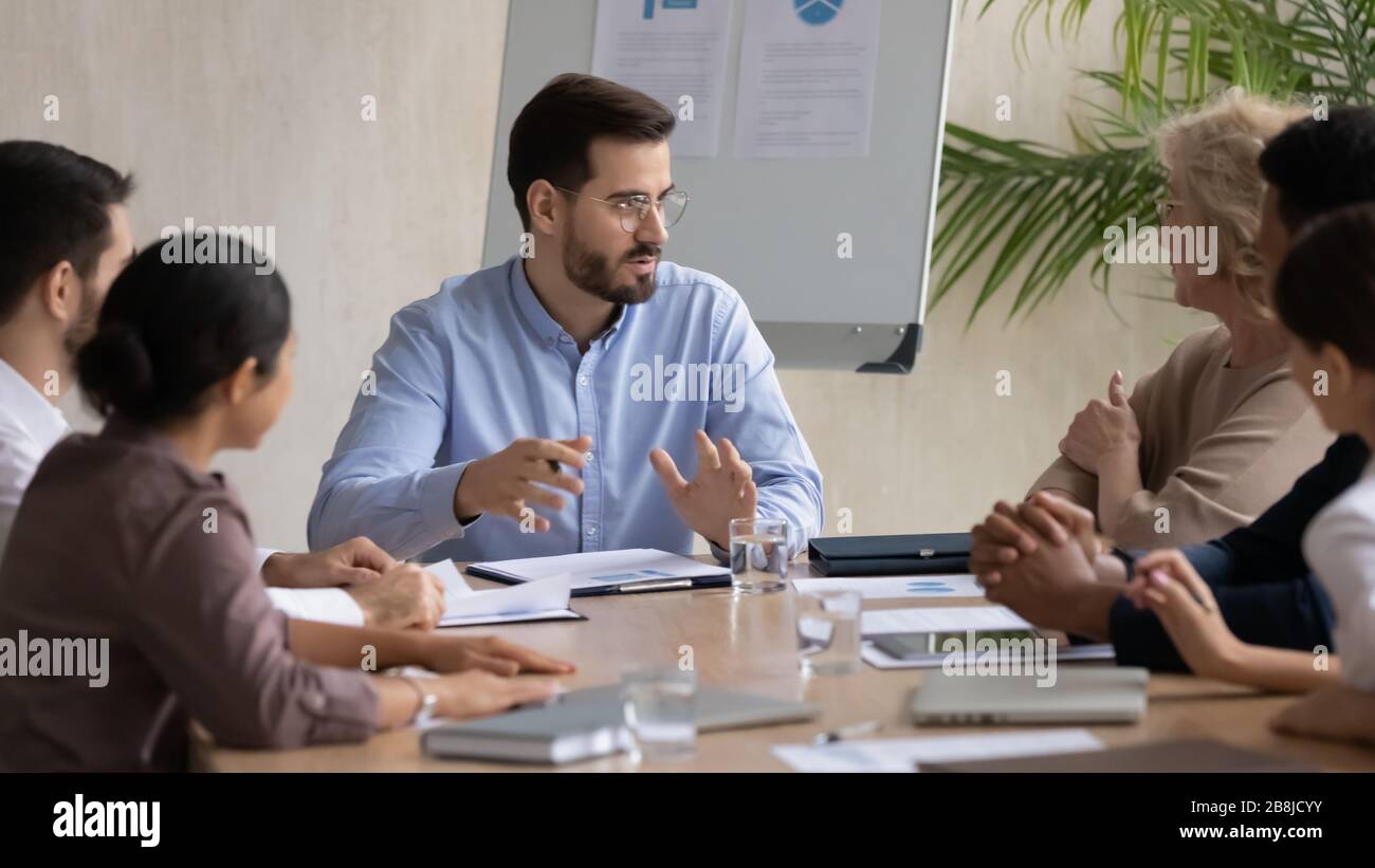 Concentrated businesspeople discuss business ideas at office meeting ...