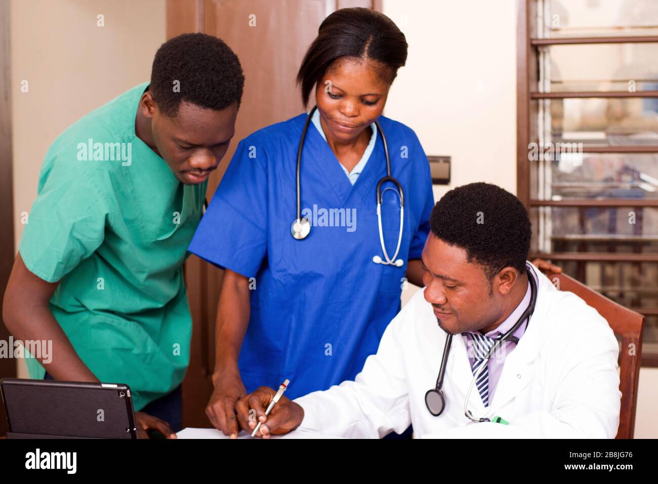 group of mixed doctors with tablet computers meeting at medical office ...