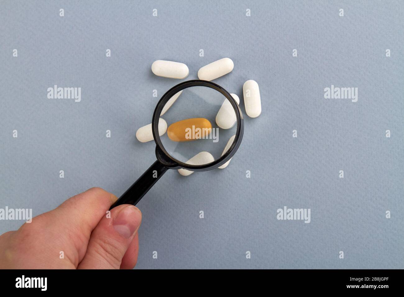 Observing pills medicines using magnifying glass Stock Photo - Alamy